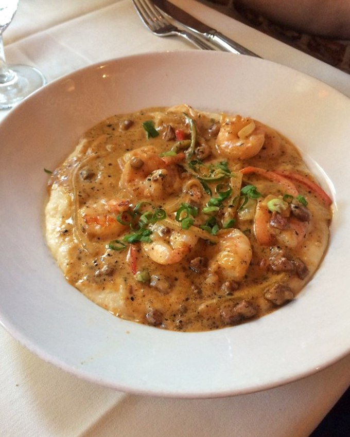 Low-country magic in a bowl: plump shrimp nestled in creamy grits creates a symphony of flavors that whispers "Welcome to Charleston" with every spoonful. 