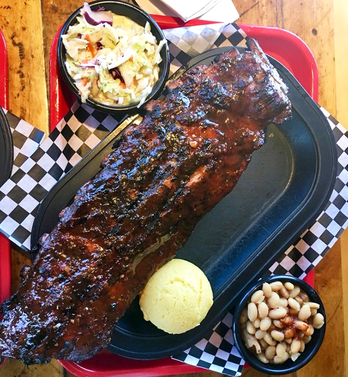 Behold, the BBQ trifecta: glistening ribs with that perfect bark, cornbread that doesn't know it's not dessert, and sides that refuse to be afterthoughts.