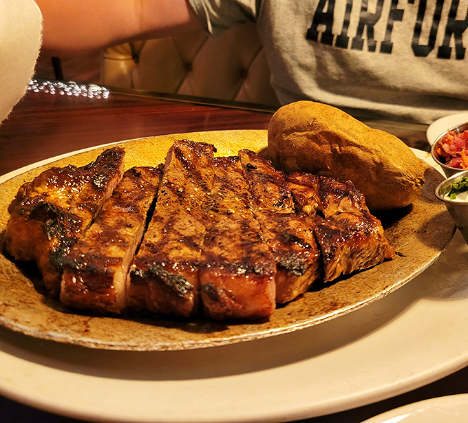 This isn't just a steak; it's a masterclass in simplicity. Perfectly charred exterior, juicy interior, and a baked potato standing by for moral support.