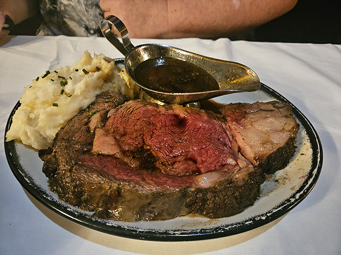 Behold the prime rib in its natural habitat&mdash;perfectly pink, swimming in au jus, with mashed potatoes standing guard. Meat poetry on a plate.