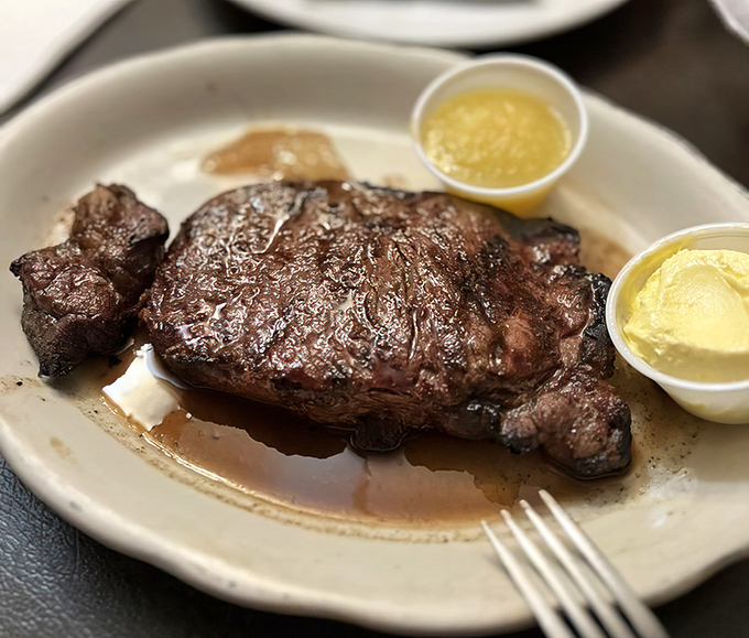 Behold the star of the show: a perfectly seared steak resting in its own glorious juices, flanked by butter cups like royal attendants.