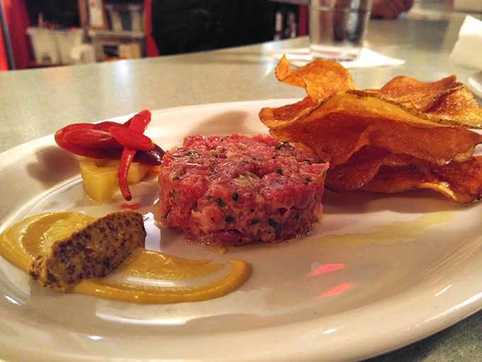 The steak tartare arrives like edible jewelry&mdash;ruby-red perfection with mustard and house-made chips that shatter satisfyingly between your teeth.