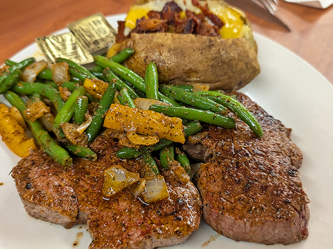 This isn't just steak—it's a masterclass in simplicity. Perfectly seasoned beef alongside vibrant green beans and a loaded potato that's practically begging to be devoured.