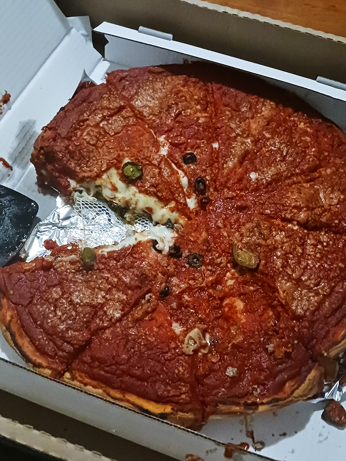 Chicago-style stuffed pizza in its natural habitat. That magnificent cheese pull is what dreams—and late-night cravings—are made of.