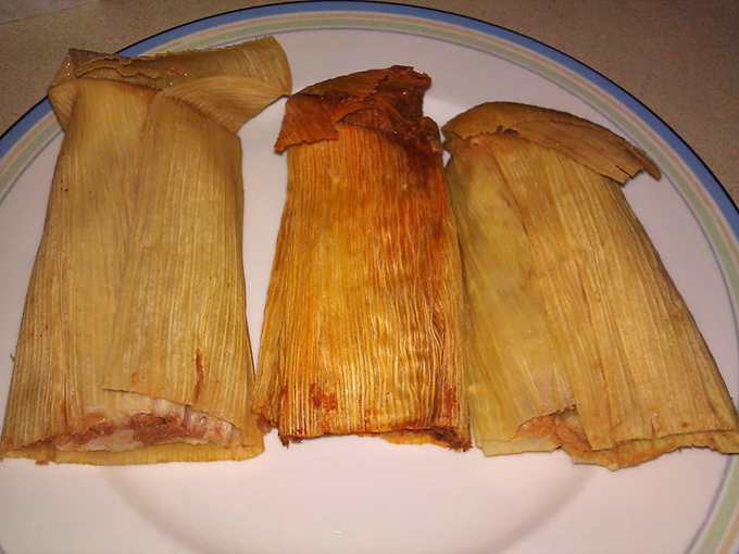 Three amigos of tamales wrapped in corn husks, each one a steamy surprise package of deliciousness.