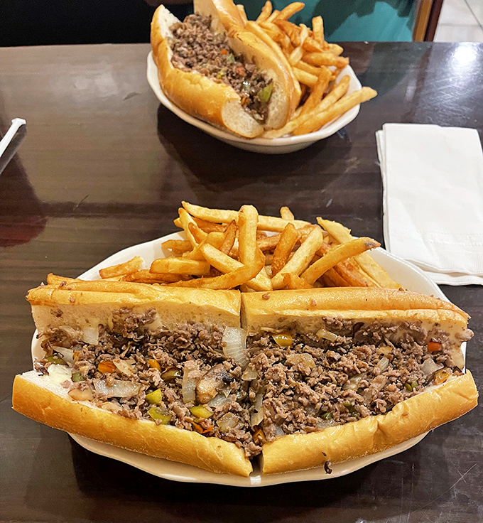 This cheesesteak isn't just a sandwich, it's an architectural marvel of beef, melted cheese, and perfectly sautéed onions flanked by golden fries.