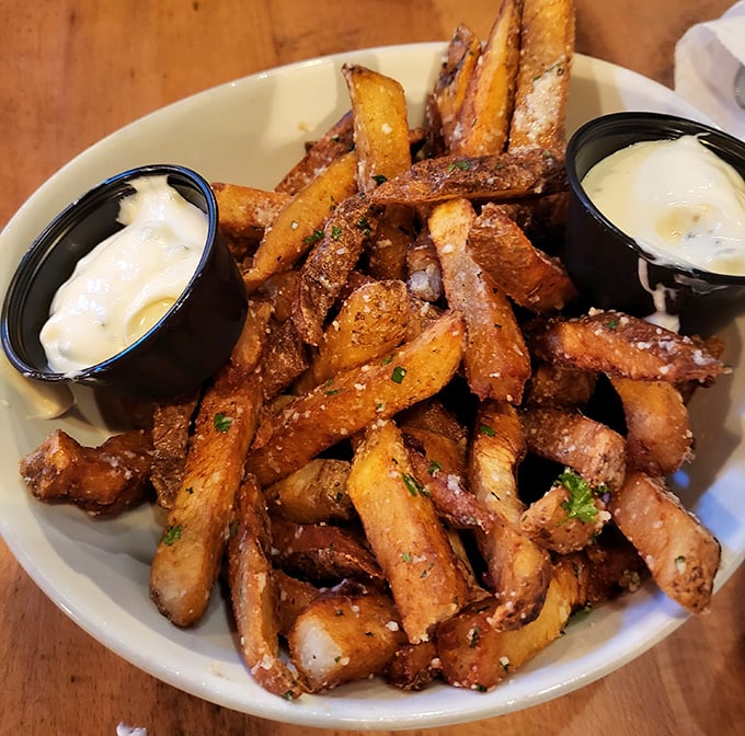 Golden, hand-cut truffle fries that could make a potato farmer weep with joy, served with dipping sauces that elevate the humble spud to art form.