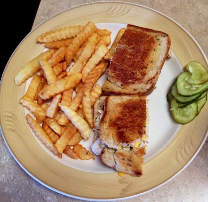 The humble sandwich, elevated to art form. Golden-brown toast, perfectly crisp fries, and those pickle slices standing guard like crunchy sentinels of flavor.