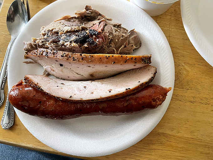 A holy trinity of smoked perfection: Turkey that defies dryness, pulled pork with perfect bark-to-meat ratio, and a sausage that makes you question your life choices.