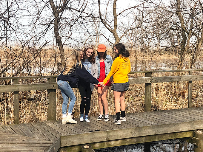 Four friends finding their balance on the boardwalk&mdash;proof that nature's playground works better than any team-building exercise corporate America could devise. 