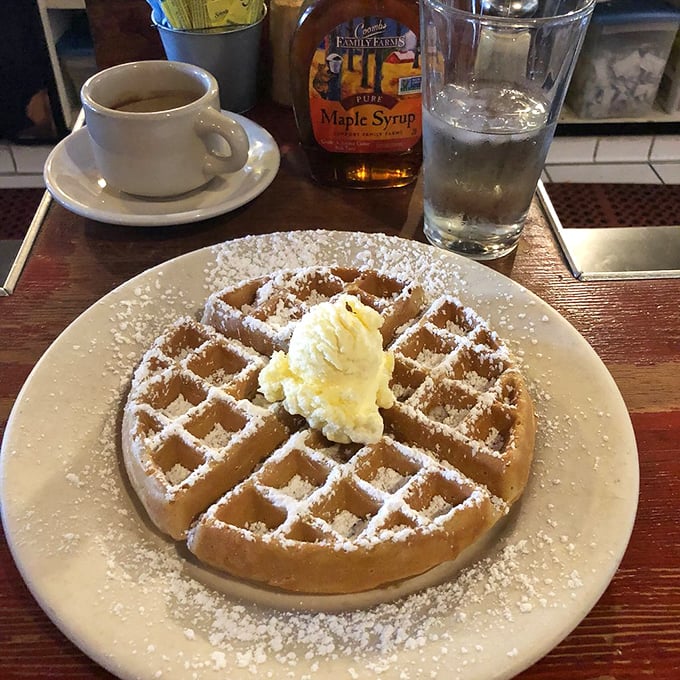 Golden perfection meets powdered sugar in a waffle romance that Hollywood screenwriters couldn't have scripted better.