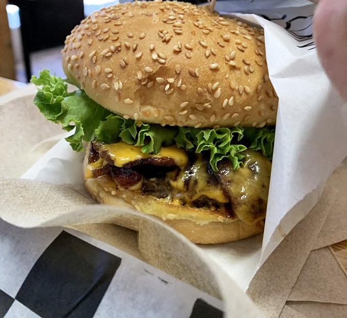 This isn't just a burger; it's edible architecture&mdash;a masterpiece of melted cheese, fresh lettuce, and a sesame-studded crown fit for royalty.