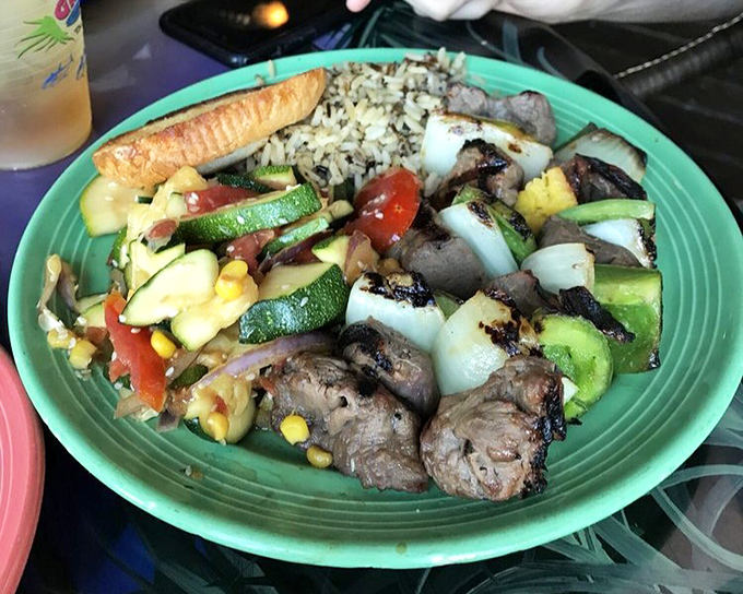Kabob perfection isn't just about the meat—it's the colorful medley of vegetables, the char marks, and that bed of coconut rice that seals the deal.