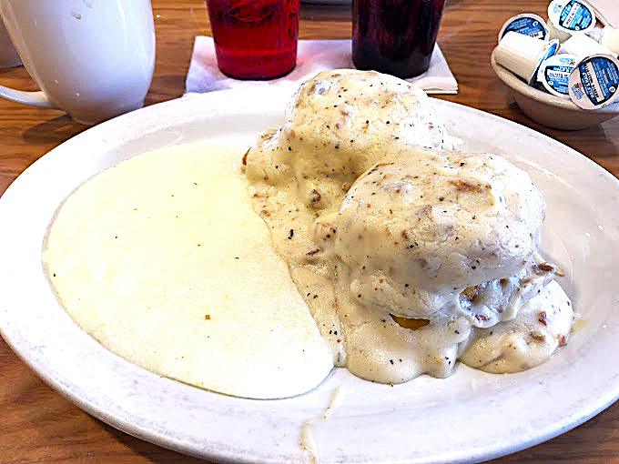 Behold the star attraction: pillowy biscuits drowning in peppery sausage gravy. This isn't just breakfast&mdash;it's an edible hug for your soul.