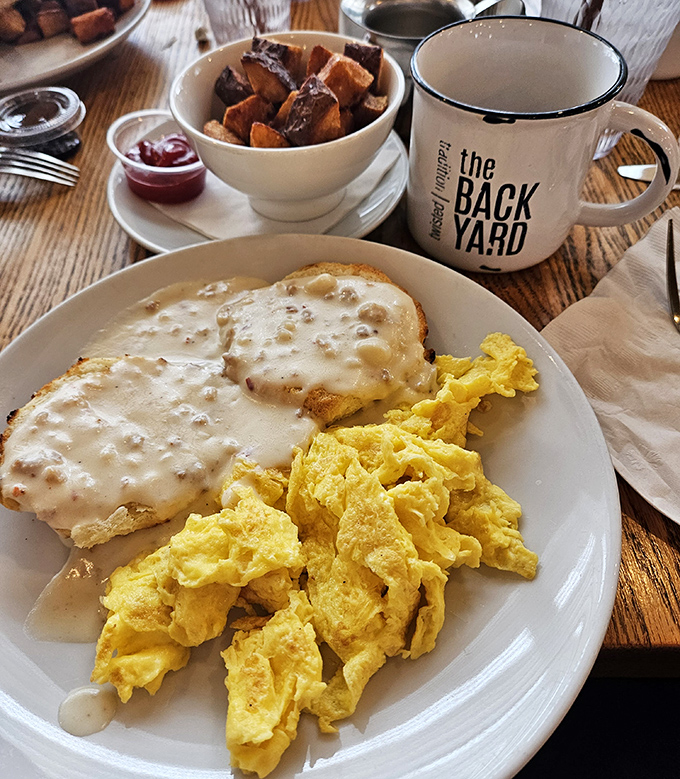 Breakfast nirvana: fluffy scrambled eggs alongside creamy biscuits smothered in savory gravy. That coffee mug isn't just for show&mdash;you'll need it.