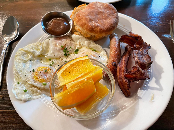Sunny-side eggs, a golden biscuit, crispy bacon, and fresh fruit—this breakfast plate isn't just a meal, it's a morning masterpiece.