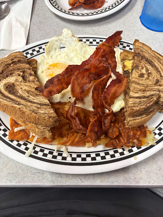 Breakfast perfection on a plate: crispy bacon, perfectly fried eggs, and marble rye toast that would make Jerry Seinfeld weep with joy.