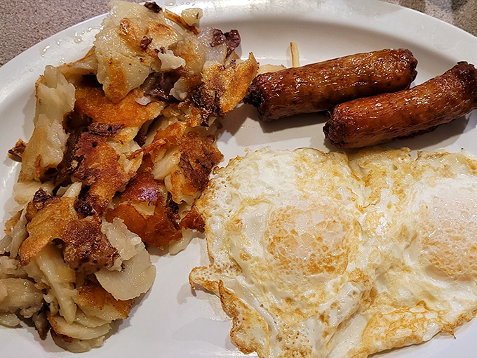 Breakfast perfection doesn't need fancy plating. These sunny-side-up eggs with home fries and sausage links are the morning equivalent of a standing ovation.