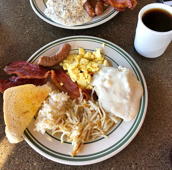 Breakfast nirvana achieved: crispy hash browns, country gravy, and bacon cooked to that perfect sweet spot between chewy and crisp.