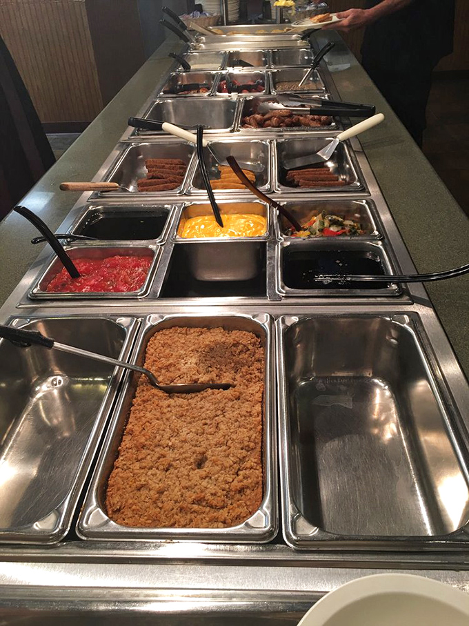 The buffet line stretches like a highway to heaven, with each steam tray promising different delights. That crumbly topping in front? Probably hiding something magical underneath.