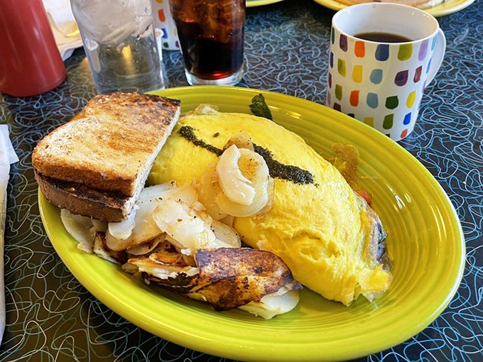This isn't just an omelet&mdash;it's a golden envelope of morning joy, delivering its cheesy contents alongside perfectly crisped potatoes and toast. 