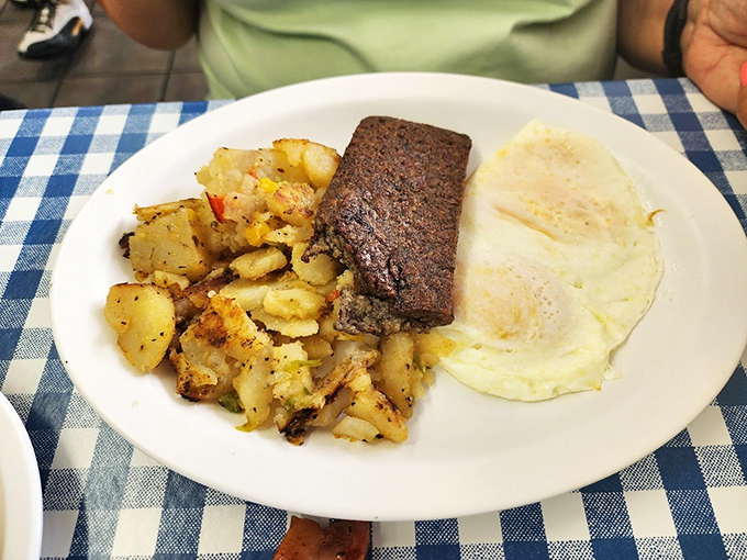 Breakfast nirvana achieved: perfectly seasoned home fries, scrapple cooked to crispy-edged perfection, and eggs so properly cooked they deserve their own culinary medal.