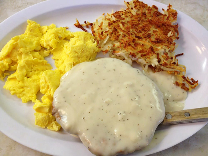 Breakfast nirvana: golden scrambled eggs, crispy hash browns, and country gravy that would make your grandmother both jealous and proud.