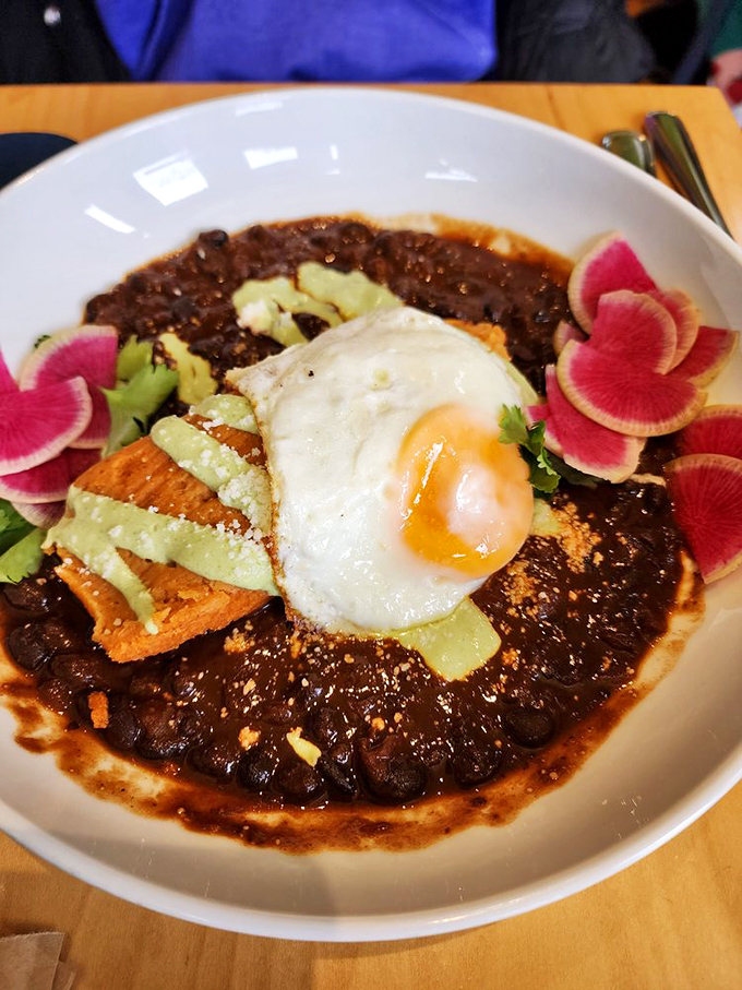 Black beans cradle a perfectly fried egg in this breakfast bowl, with watermelon radish adding pops of color that wake up your senses.