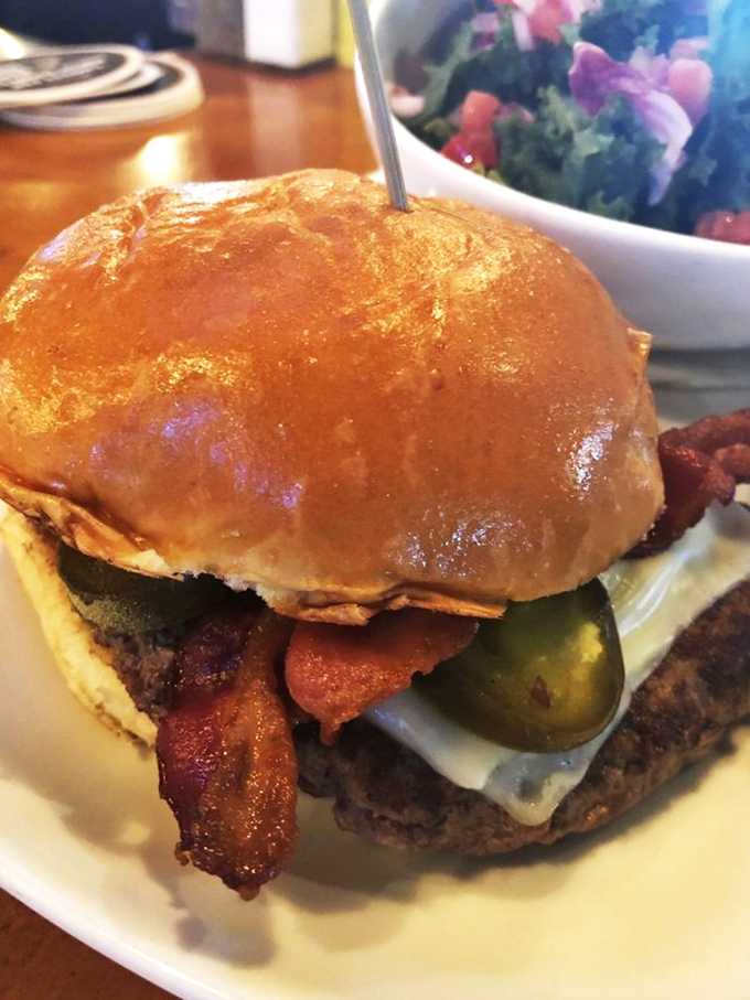 This isn't just a burger &ndash; it's an architectural marvel of beef, bacon, and pickle that requires both hands, several napkins, and absolutely zero regrets.