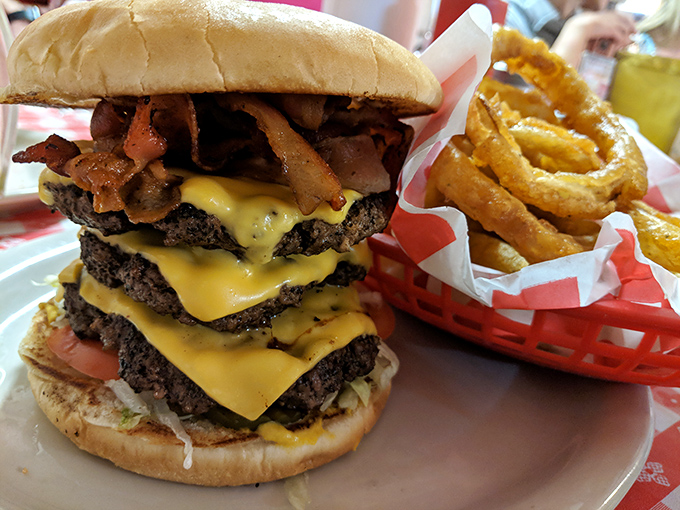 Not so much a burger as a skyscraper of beef. This towering achievement makes you wonder if you should eat it or apply for a building permit.