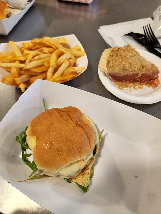 This isn't just a burger&mdash;it's a handheld masterpiece with a supporting cast of golden fries and what appears to be pie in the background. Strategic ordering!