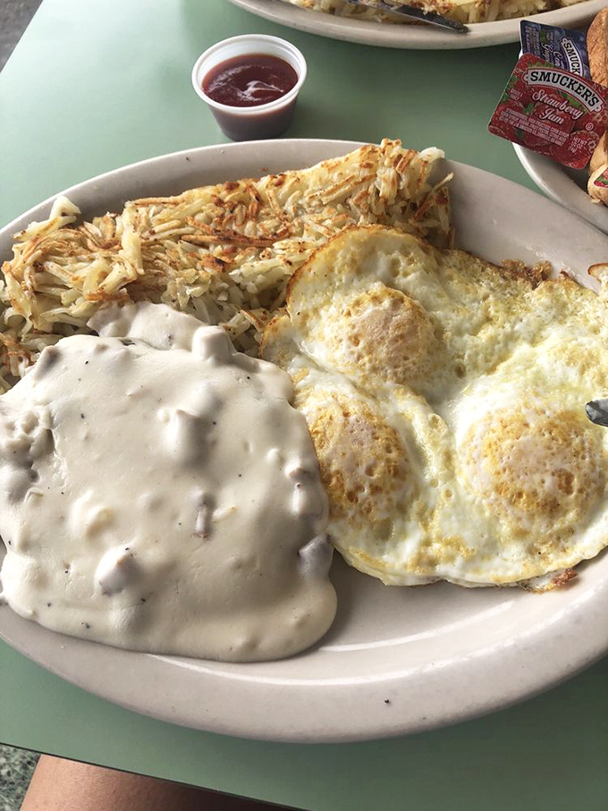 Country gravy cascading over crispy chicken fried steak like a delicious waterfall. The hash browns are the supporting act in this breakfast symphony.