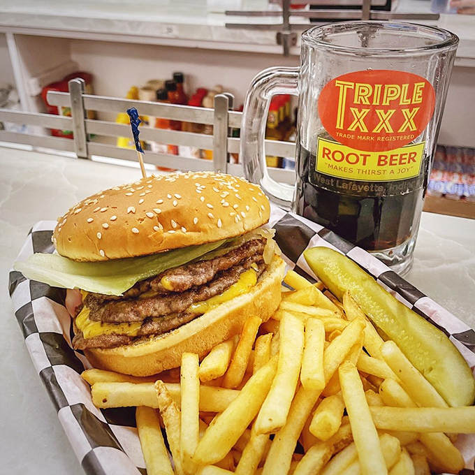 The perfect trifecta: a towering burger that requires jaw exercises, golden fries that snap with each bite, and a frosted mug of house root beer.