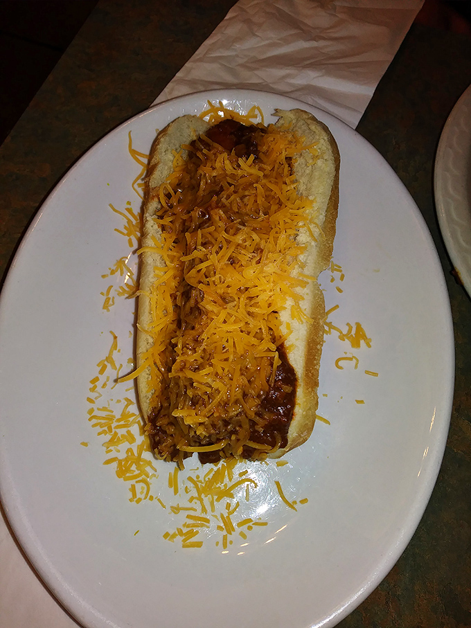 Behold the King Coney in all its cheese-crowned glory. That vibrant orange cheddar blanket melting into the signature meat sauce is what comfort food dreams are made of.