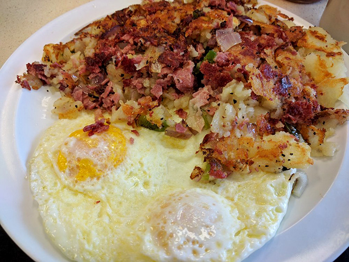 Corned beef hash that doesn't hide behind fancy descriptions &ndash; just glorious, crispy-edged potatoes mingling with savory meat beneath perfectly cooked eggs.