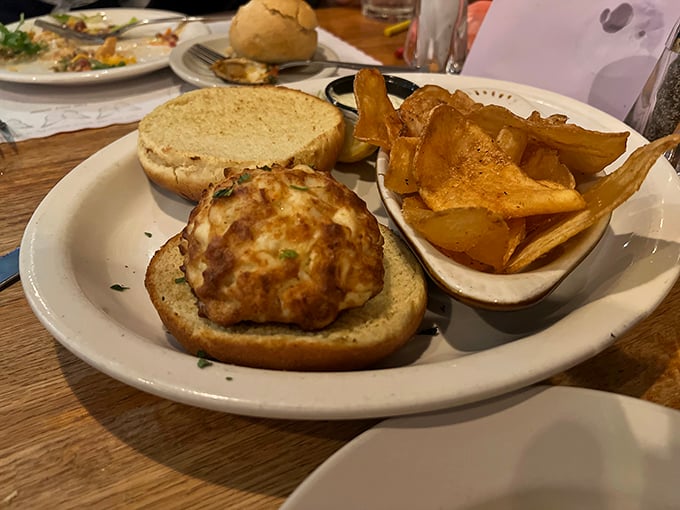 The crab cake sandwich arrives like a golden medallion of the sea, perfectly bronzed and paired with house-made chips that crackle with each satisfying bite.