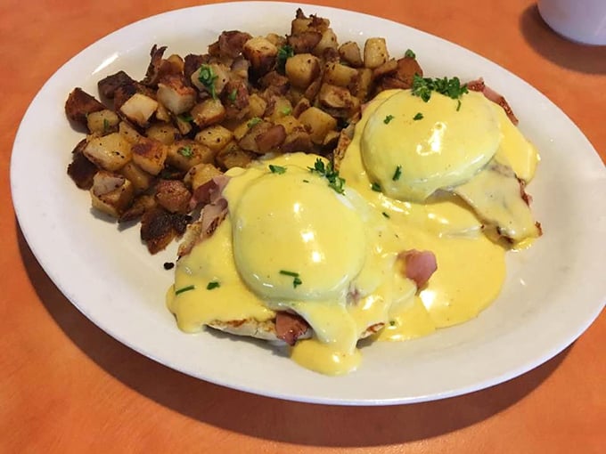 Benedict perfection: golden hollandaise cascading over poached eggs like a sunrise, with home fries crisped to mathematical precision.