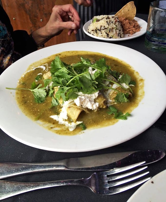 This isn't just an enchilada&mdash;it's a flavor revelation swimming in verdant salsa, topped with fresh cilantro and a generous dollop of Mexican cheese.