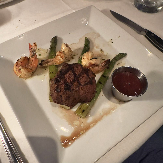 A perfectly seared filet mignon shares the plate with plump shrimp and asparagus spears &ndash; proof that surf and turf isn't just a pairing, it's a philosophy.