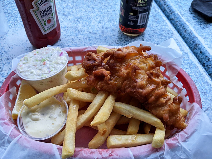 Golden-battered grouper perched atop a throne of crispy fries. Coleslaw stands guard, tartar sauce waits patiently. This is edible artwork.
