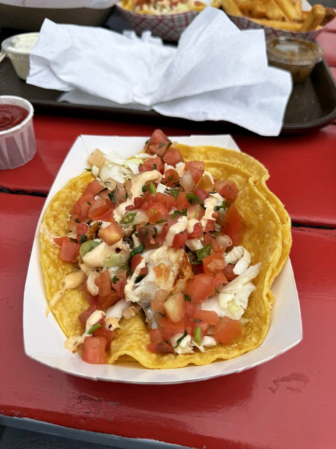 The legendary fish taco in its natural habitat&mdash;corn tortillas cradling perfectly cooked fish beneath fresh pico de gallo and that magical drizzle of sauce.