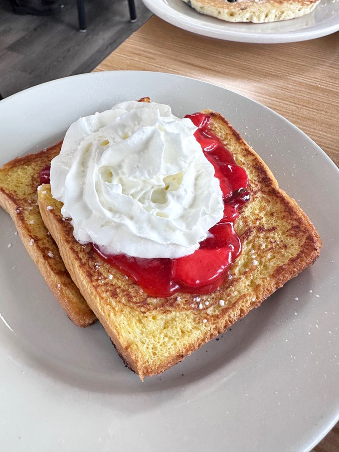 French toast elevated to art form&mdash;golden bread crowned with ruby-red filling and a cloud of whipped cream. Breakfast doesn't get more photogenic than this.
