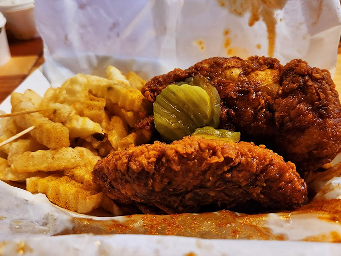 Crimson-hued chicken rests beside golden fries like a delicious warning sign. Those pickle chips aren't just garnish&mdash;they're your emergency cooling system.