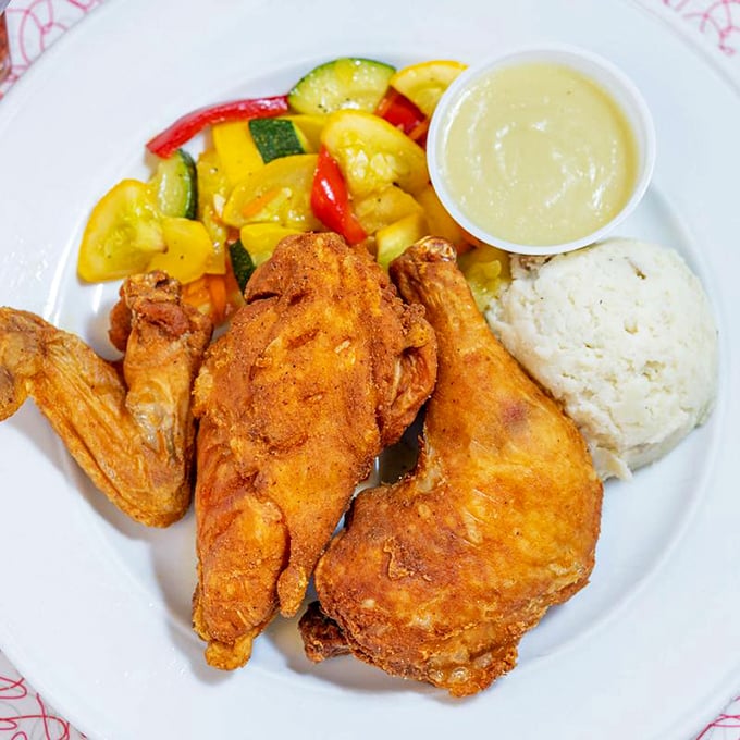 Golden-brown fried chicken that crackles with each bite, served alongside colorful vegetables and mashed potatoes that would make grandma proud.