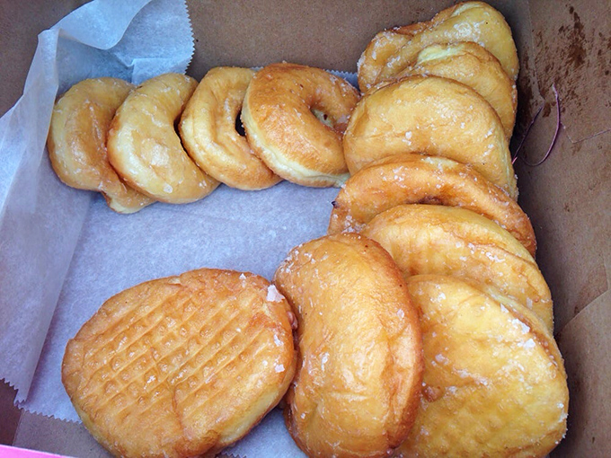 Golden pillows of fried perfection await their destiny in a simple cardboard box – these glazed donuts don't need fancy packaging.