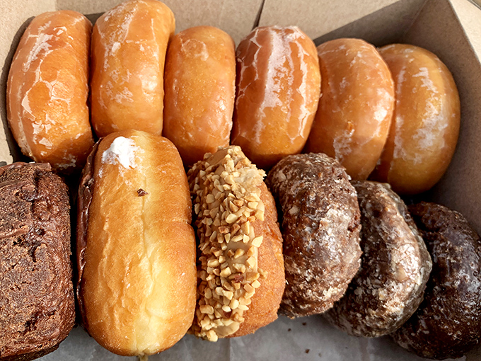 A box of golden-hued glazed donuts sits like edible sunshine, their perfect glaze crackles with promise at first bite.