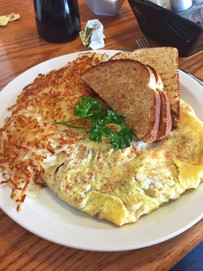 This omelet doesn't need a passport to impress—it's traveled the world in flavor while staying firmly rooted in heartland hospitality, accompanied by perfectly crispy hash browns.
