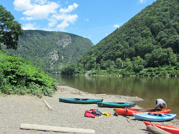 Adventure awaits at the water's edge, where colorful kayaks rest between journeys through this magnificent gorge. Paddle therapy at its finest!