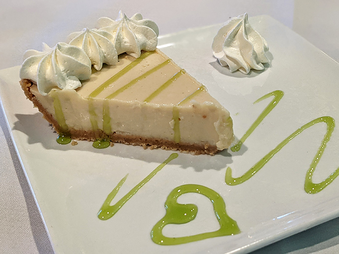 Key lime pie perfection: pale yellow custard meets graham cracker crust in holy matrimony. Those artful lime drizzles aren't just for show&mdash;they're flavor exclamation points.