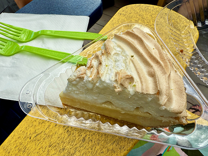 Behold the star of the show! This perfect slice reveals the holy trinity of key lime pie: creamy filling, toasted meringue, and that essential graham cracker crust.